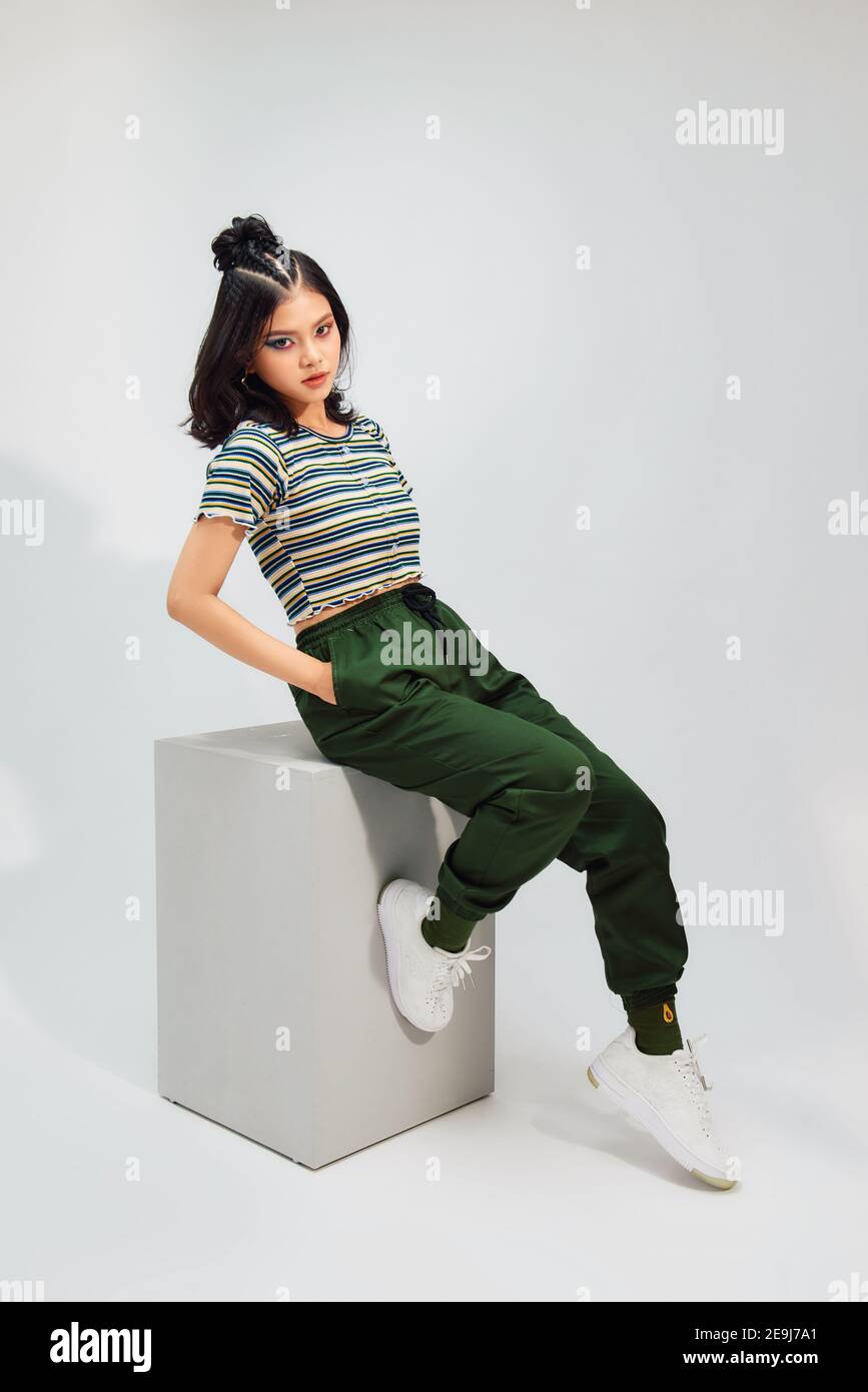 Young girl sitting on the high chair, white background Stock Photo - Alamy