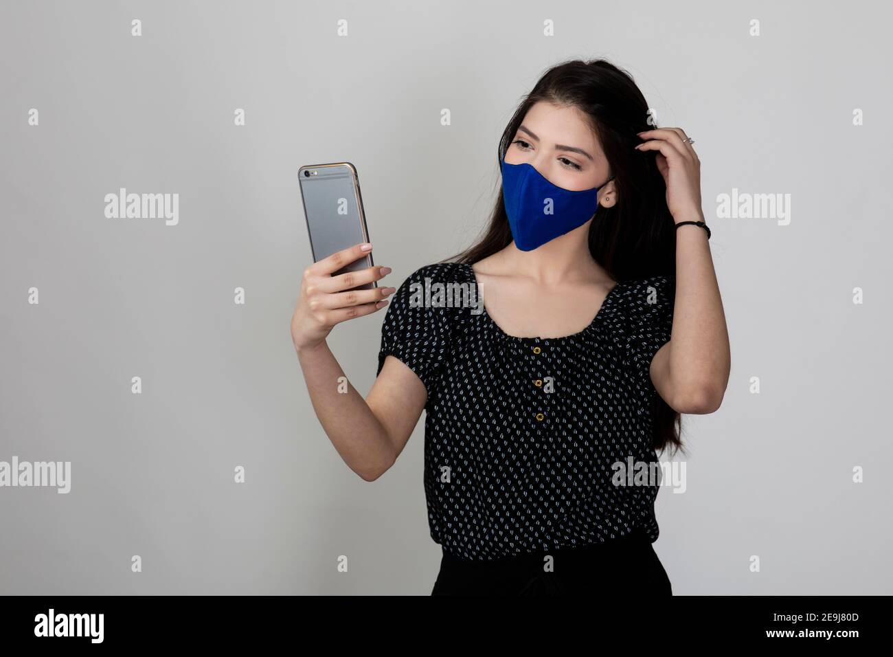 Image of a pretty young girl wearing Covid 19 protection mask while ...