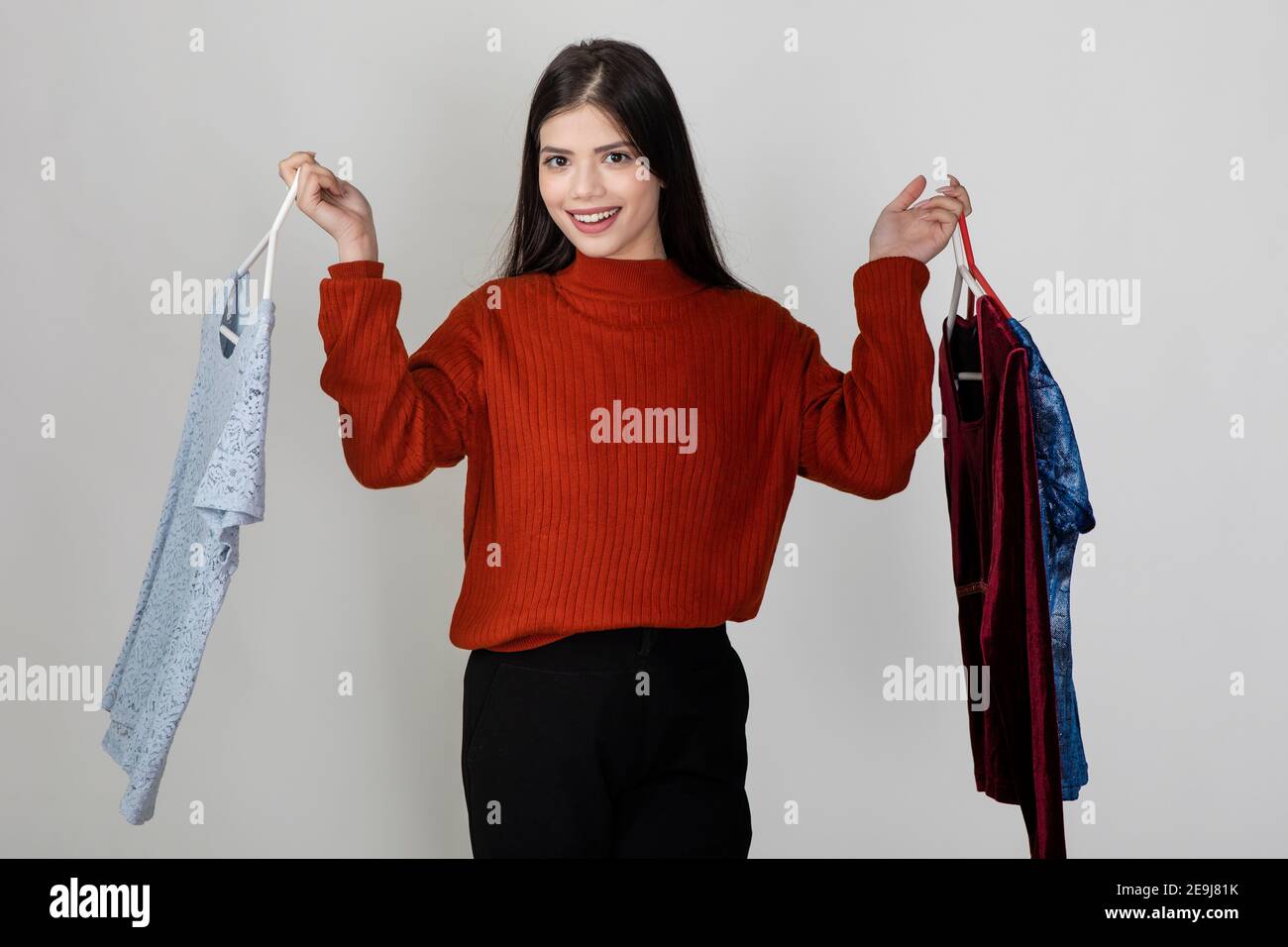 Portrait of pretty young Indian girl standing against white background ...
