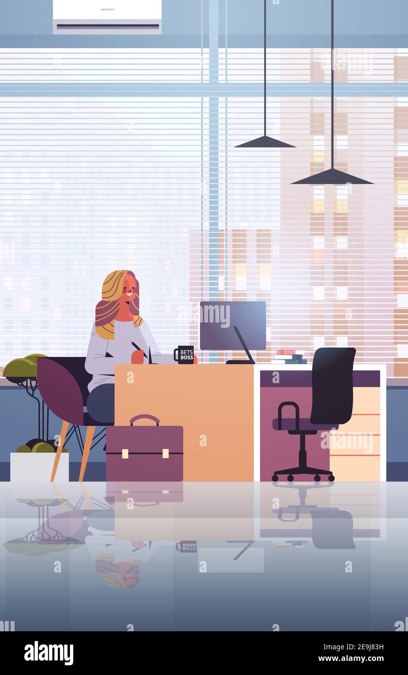 young businesswoman sitting at workplace and using computer ...