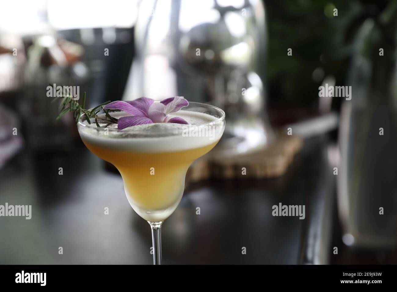 Yellow Cocktail glass with ice at a bar counter Stock Photo - Alamy