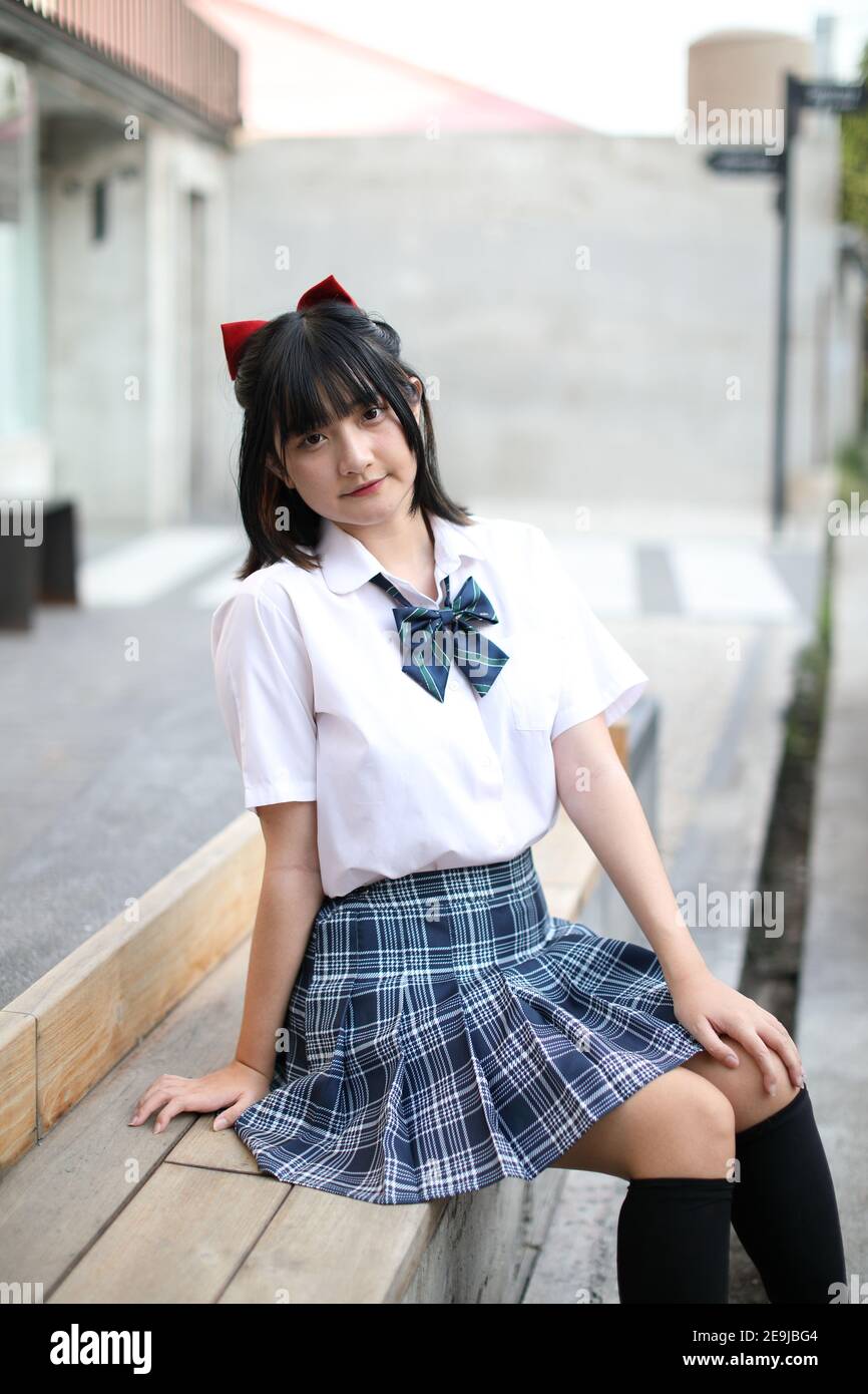 Asian school girl walking and looking at urban city Stock Photo - Alamy