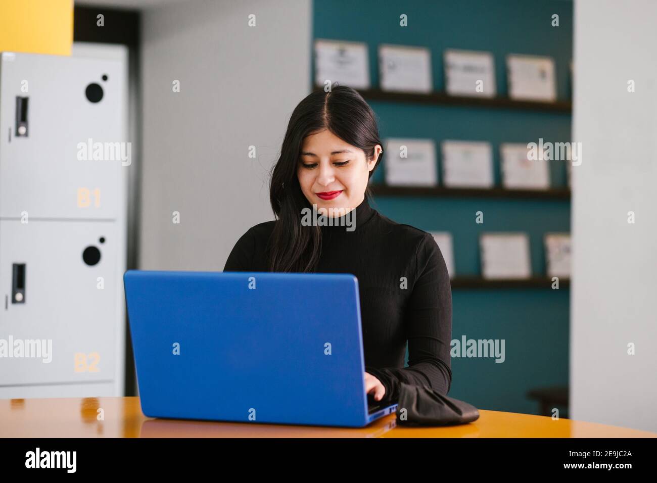 latin business woman working with computer at the office in Mexico city ...