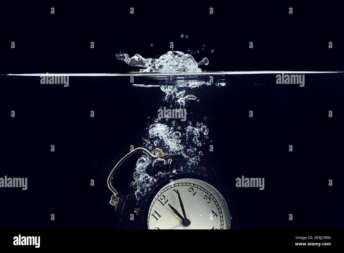 Alarm clock falling into the water against black background Stock Photo ...