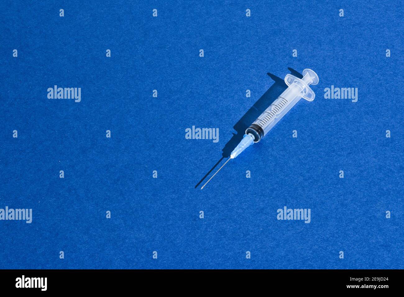 Disposable medical injection syringe on blue Stock Photo - Alamy