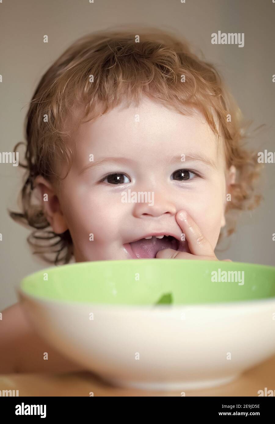 Baby eating, cute child eat. Portrait of smiling sweet kid eating from ...