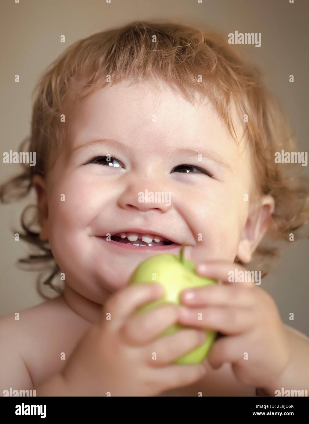 Portrait of smiling male kid with apple. Baby eating, cute child eat ...