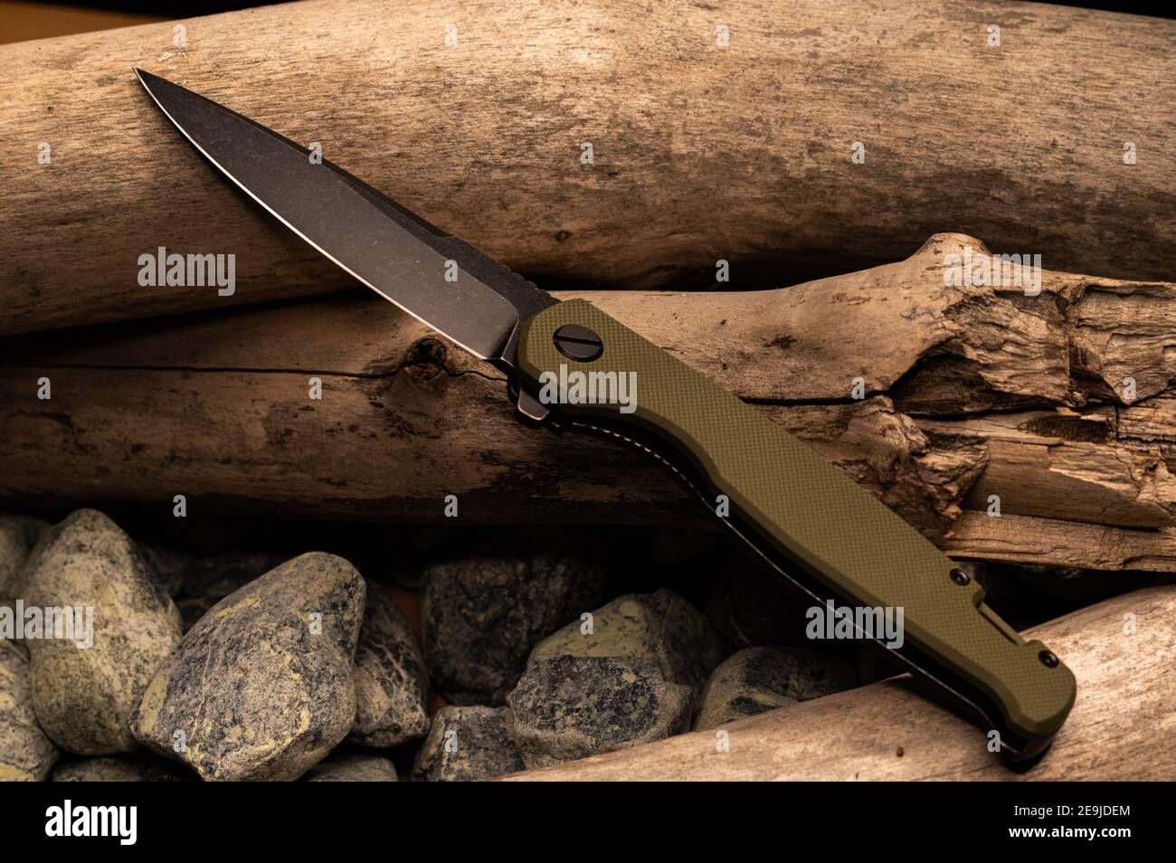 Sharp narrow knife on wood and stones. Penknife on a log. Background ...