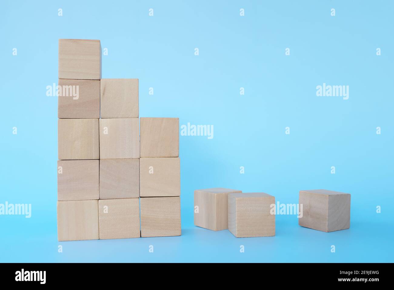 Broken or fallen building blocks in blue background. Economic crisis ...