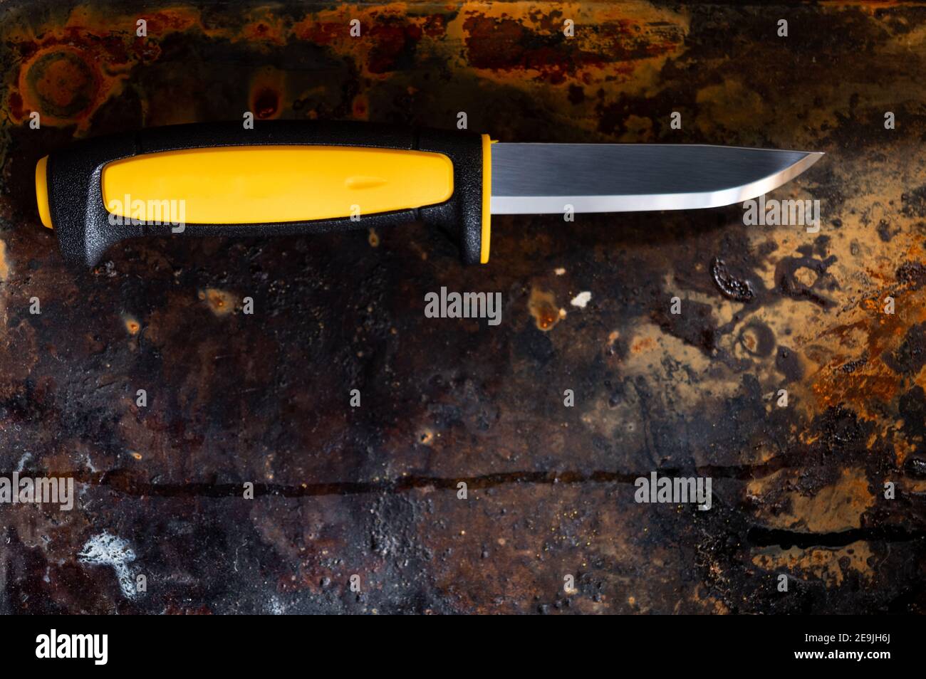Fixed blade knife. Knife with a yellow handle. Knife on a rusty ...
