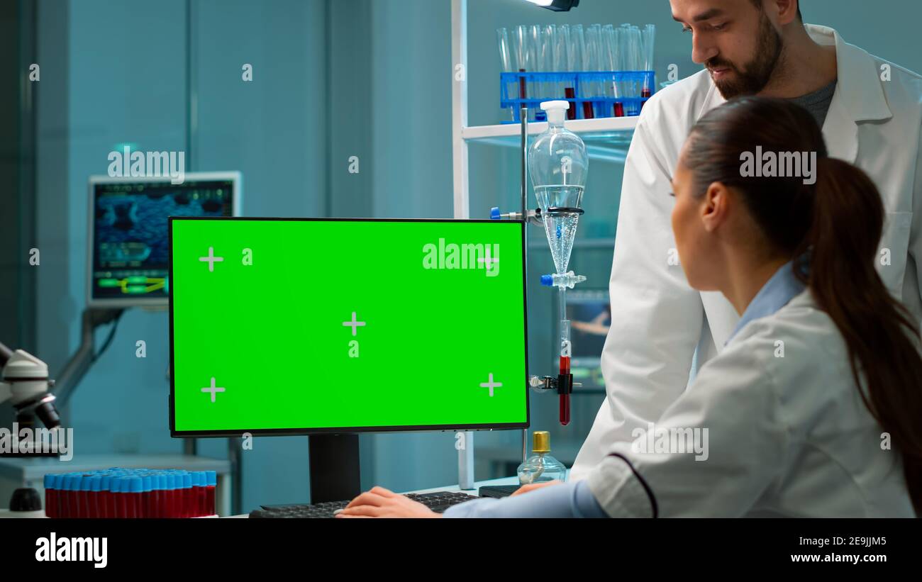 Medical research scientists using desktop computer with green screen ...
