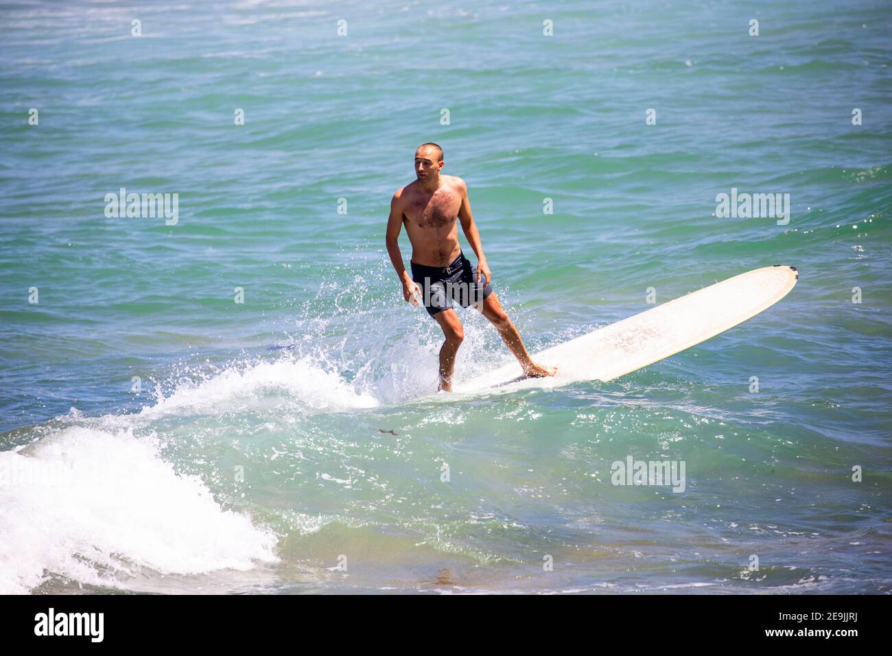 Man teenager surfing the waves at Avalon Beach in Sydney on a summers ...