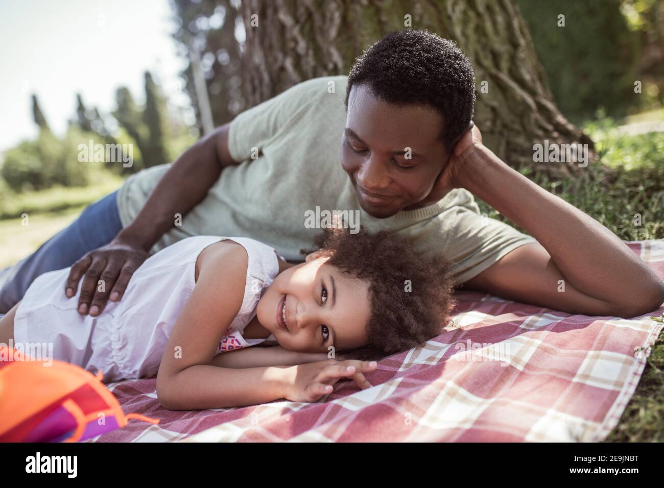 African american man and his cute kid having rest in the park Stock ...