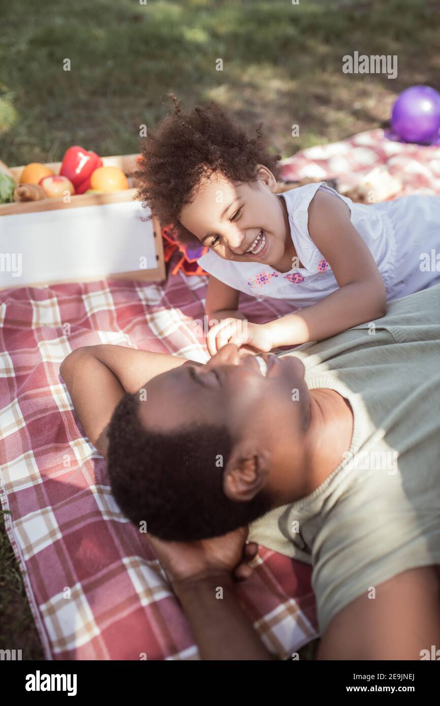 African american man and his cute kid having rest in the park and ...