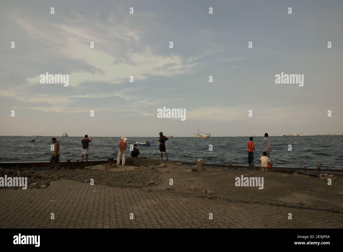 People having outdoor recreation by fishing from an abandoned harbour ...