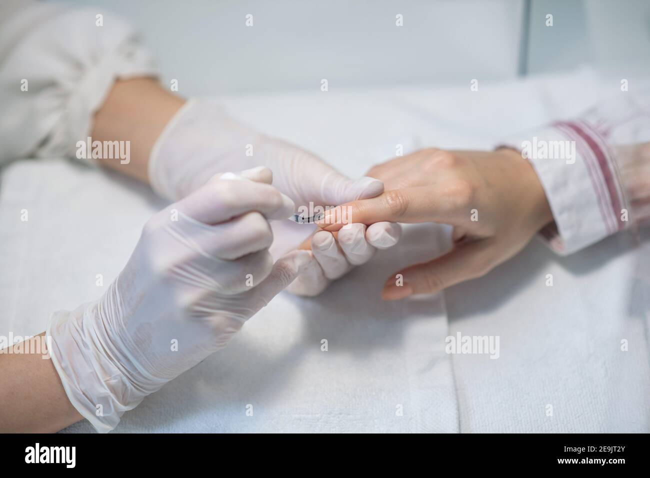 Close up picture of nail artists hands applying nail base Stock Photo ...