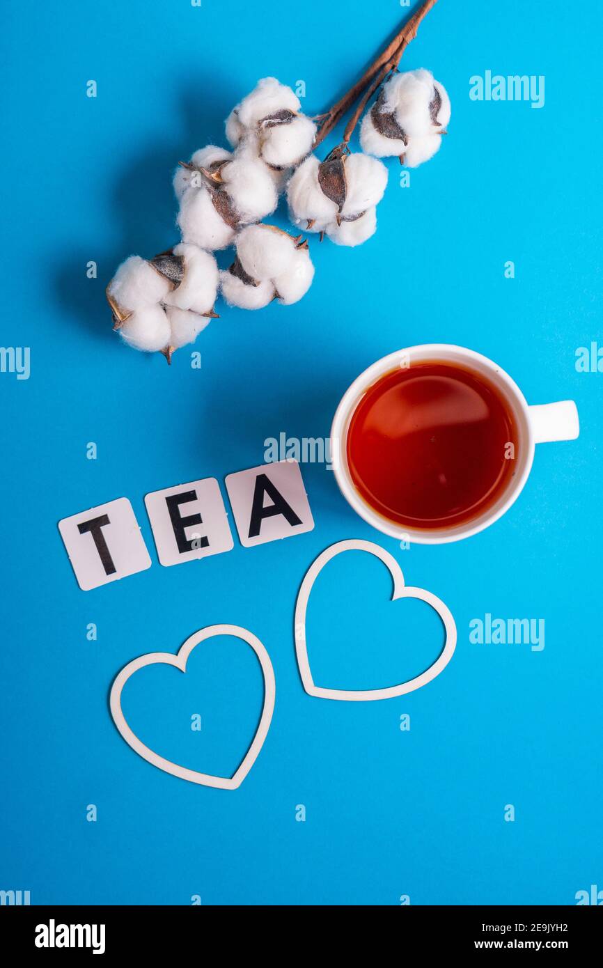selective focus: Ceylon black tea in a white mug on a blue plain paper ...
