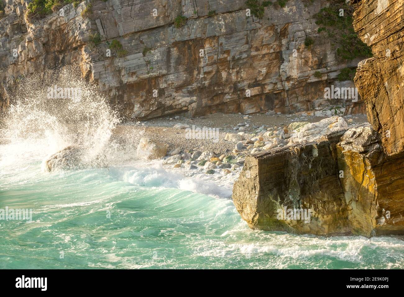 Small rocky beach and cliffs on the seashore. Early morning and surf ...