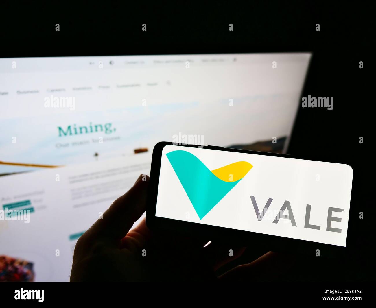 Person holding mobile phone with logo of Brazilian mining and logistics ...