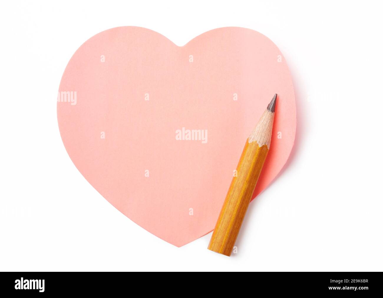 Picture of pink notepad in the shape of the heart with yellow pencil ...