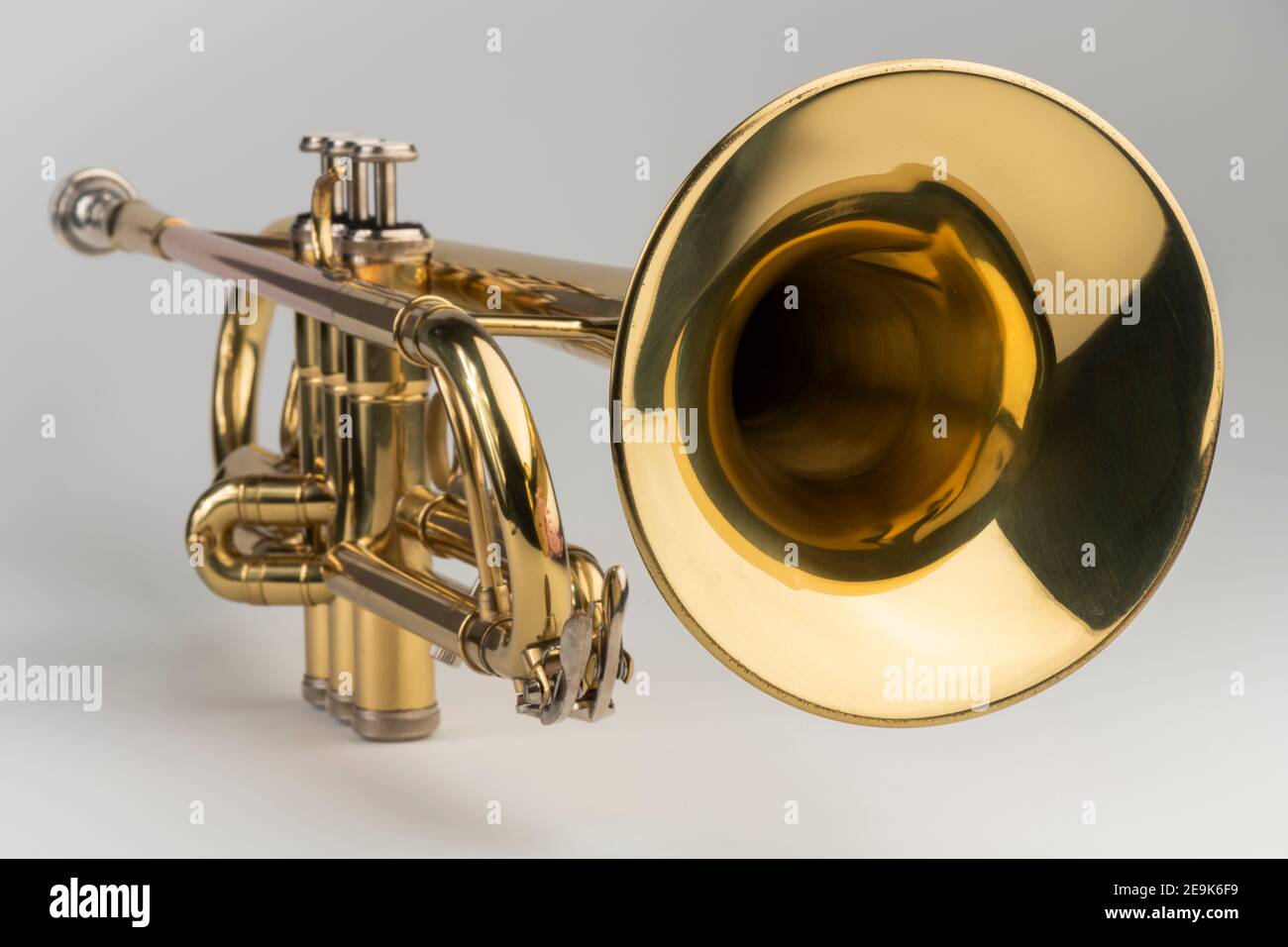 Gold colored trumpet as an isolated musical instrument against a white ...