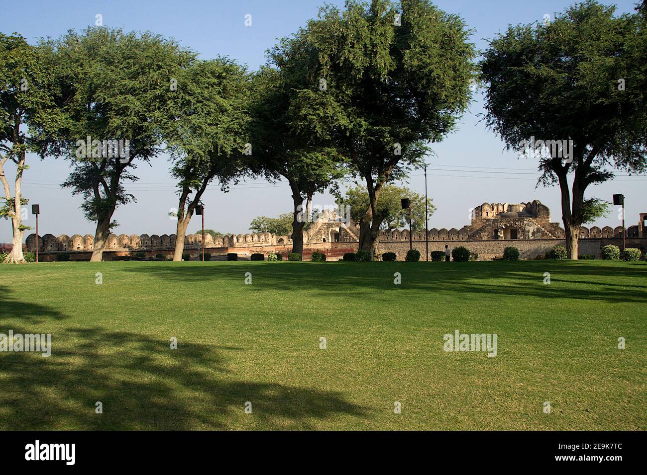 View of spacious, trimmed grass turf and lofty trees inside fort at ...