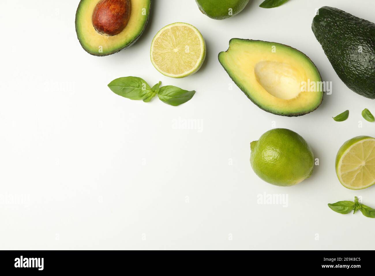 Avocado, lime and basil on white background, space for text Stock Photo ...