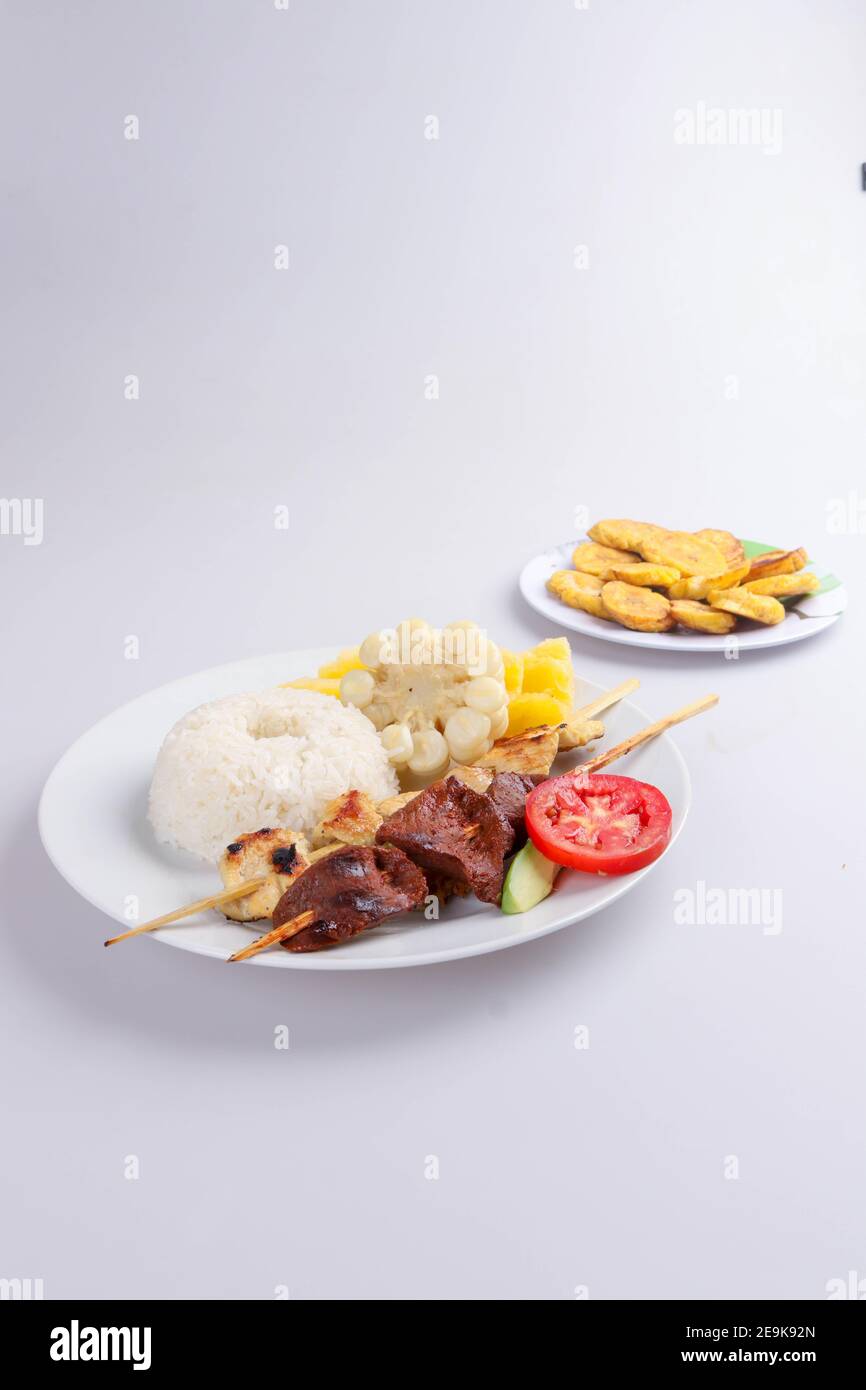 Peruvian dish called Anticucho with skewers of grilled chicken, rice ...
