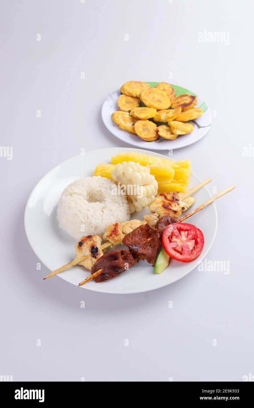 Peruvian dish called Anticucho with skewers of grilled chicken, rice ...