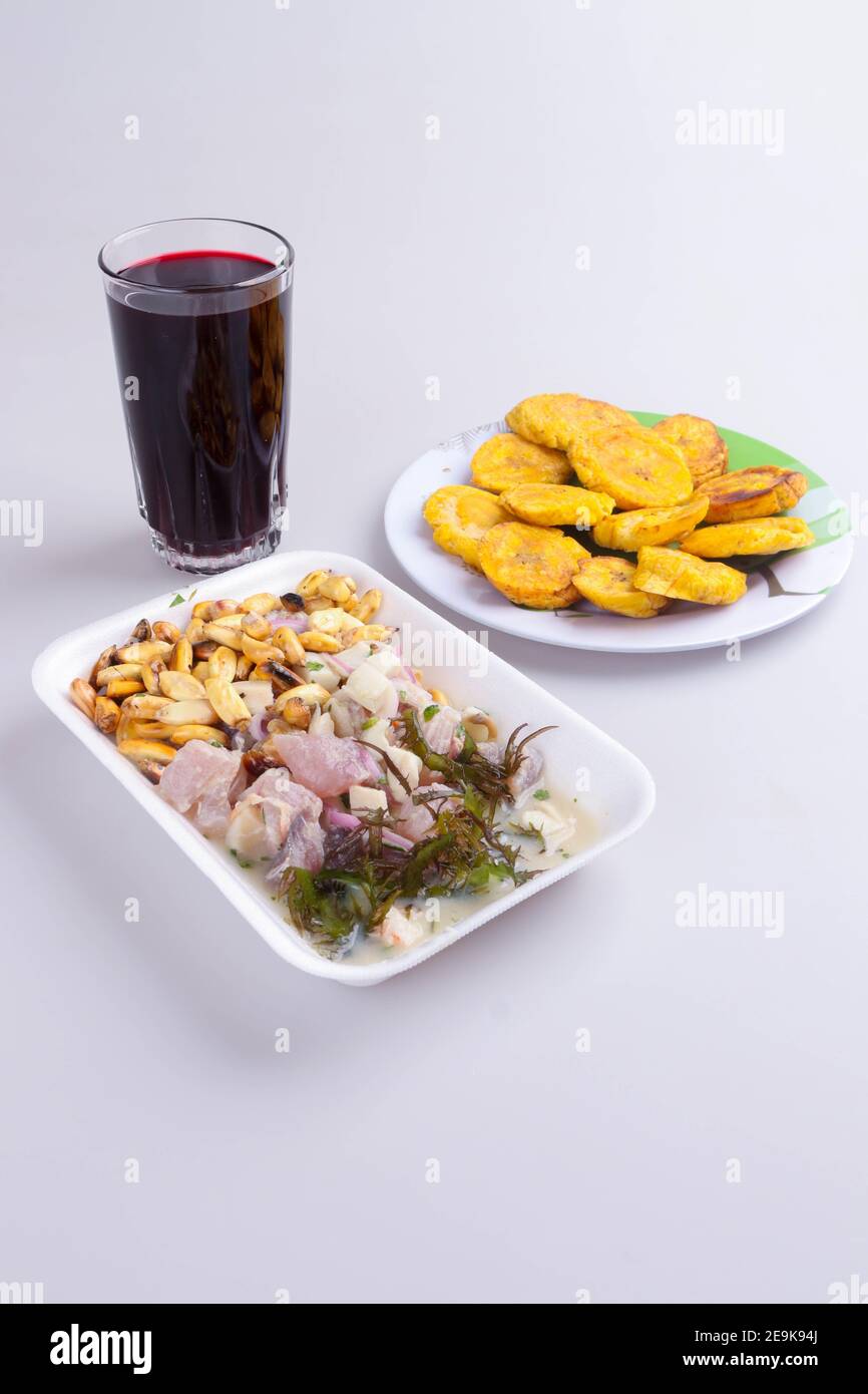 Peruvian food called ceviche with fried bananas and a glass of chicha ...