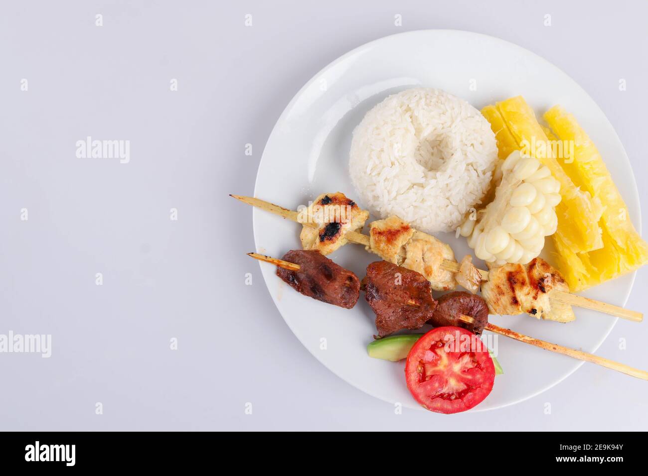 Peruvian dish called Anticucho with skewers of grilled chicken, rice ...
