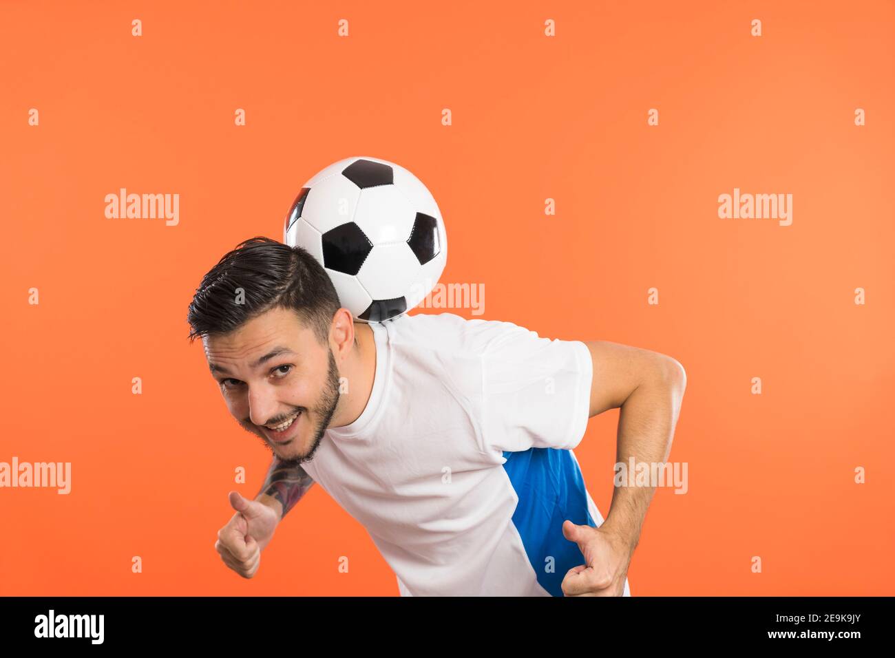 Young Man football soccer player balancing soccer ball on the back of ...