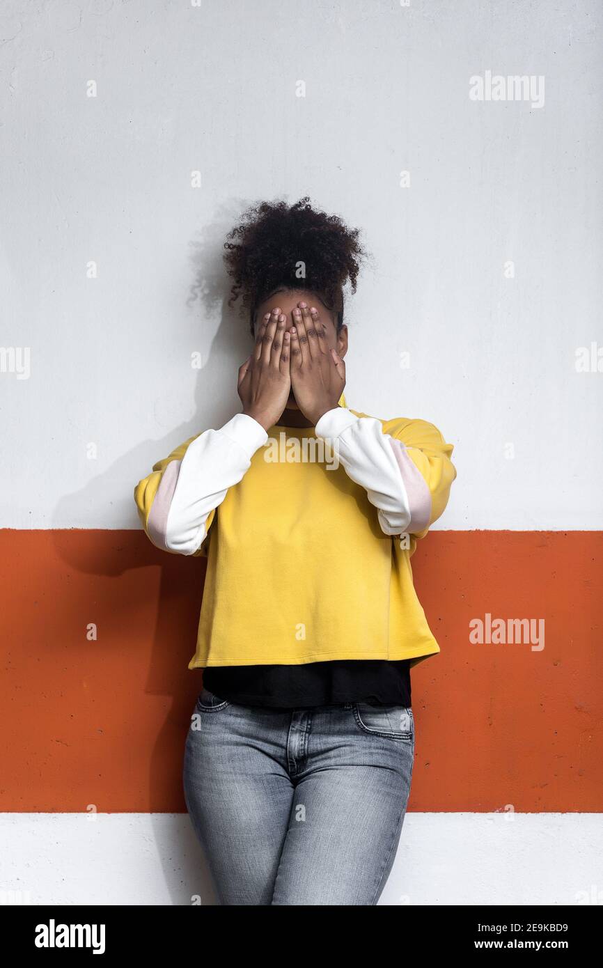 Unrecognizable African American female in bright yellow shirt and jeans ...