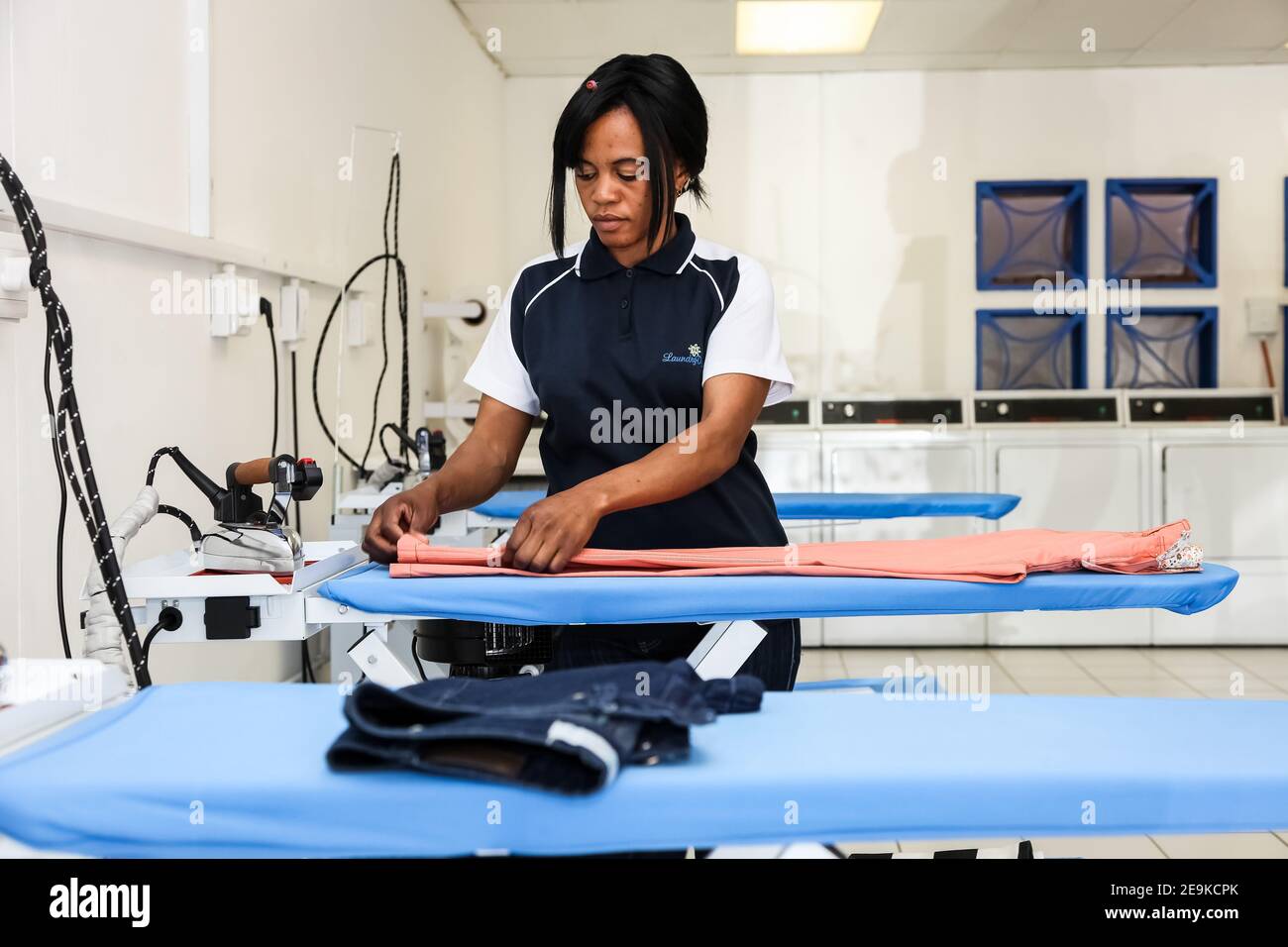 Johannesburg, South Africa - October 2, 2012: Young Black woman ironing ...
