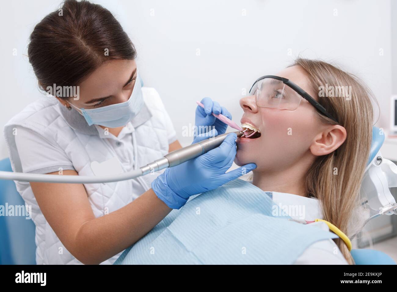 Professional dentist working at her clinic, treating teeth of female ...