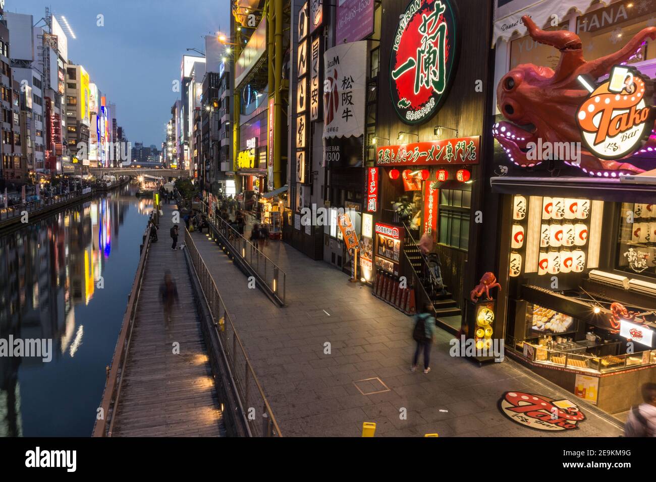Long exposure image of people walking along the Dotonbori river in ...