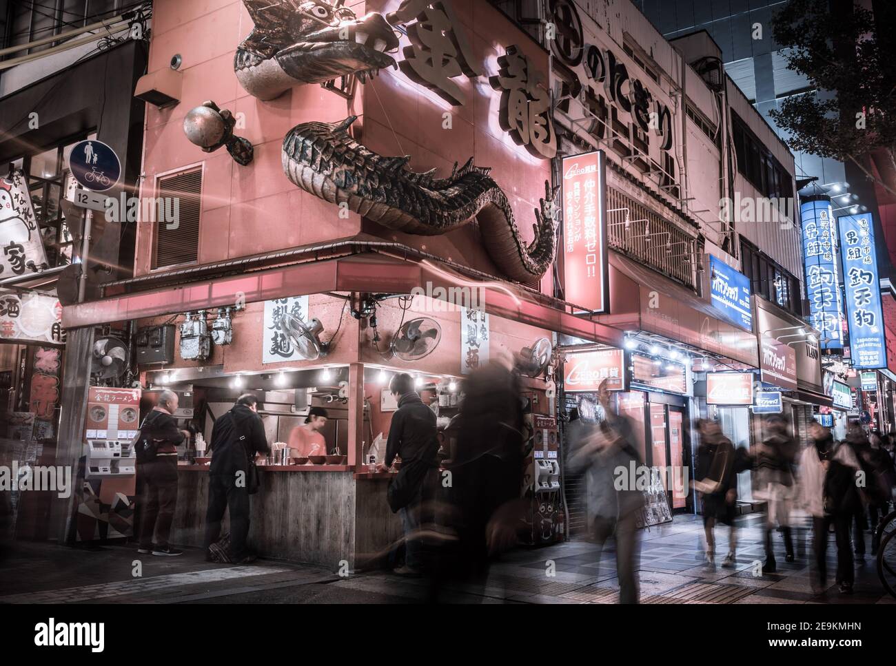 People eating outside a ramen restaurant in Dotonbori, an area of bars ...