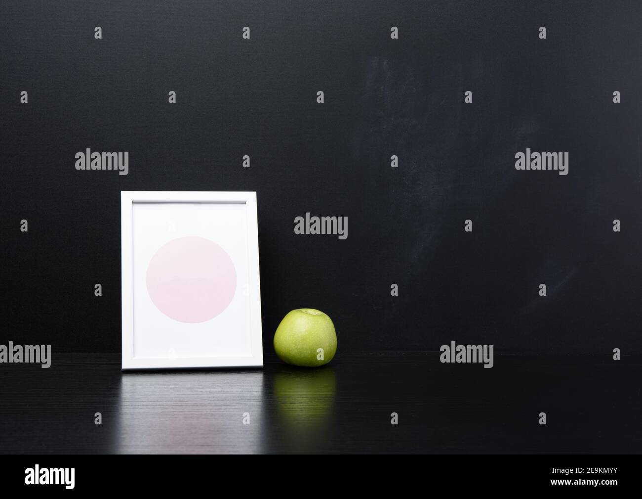green apple and empty white wooden photo frame, black wall Stock Photo ...