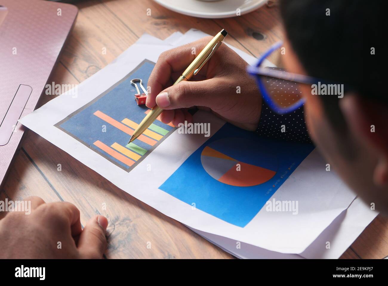 rear view of young man analyzing bar chart on paper Stock Photo - Alamy
