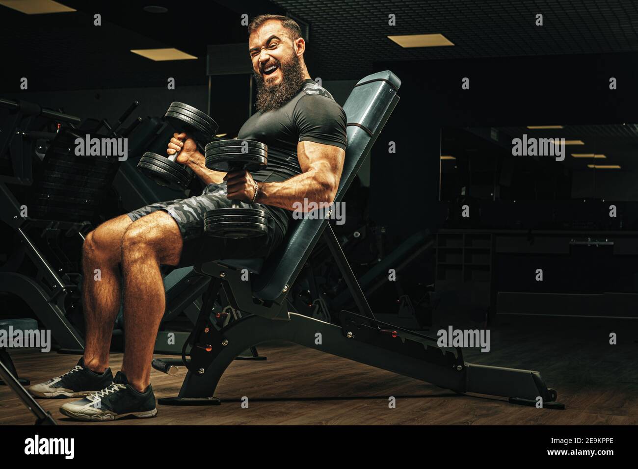 Male with sport body lifting dumbbells at the gym Stock Photo - Alamy