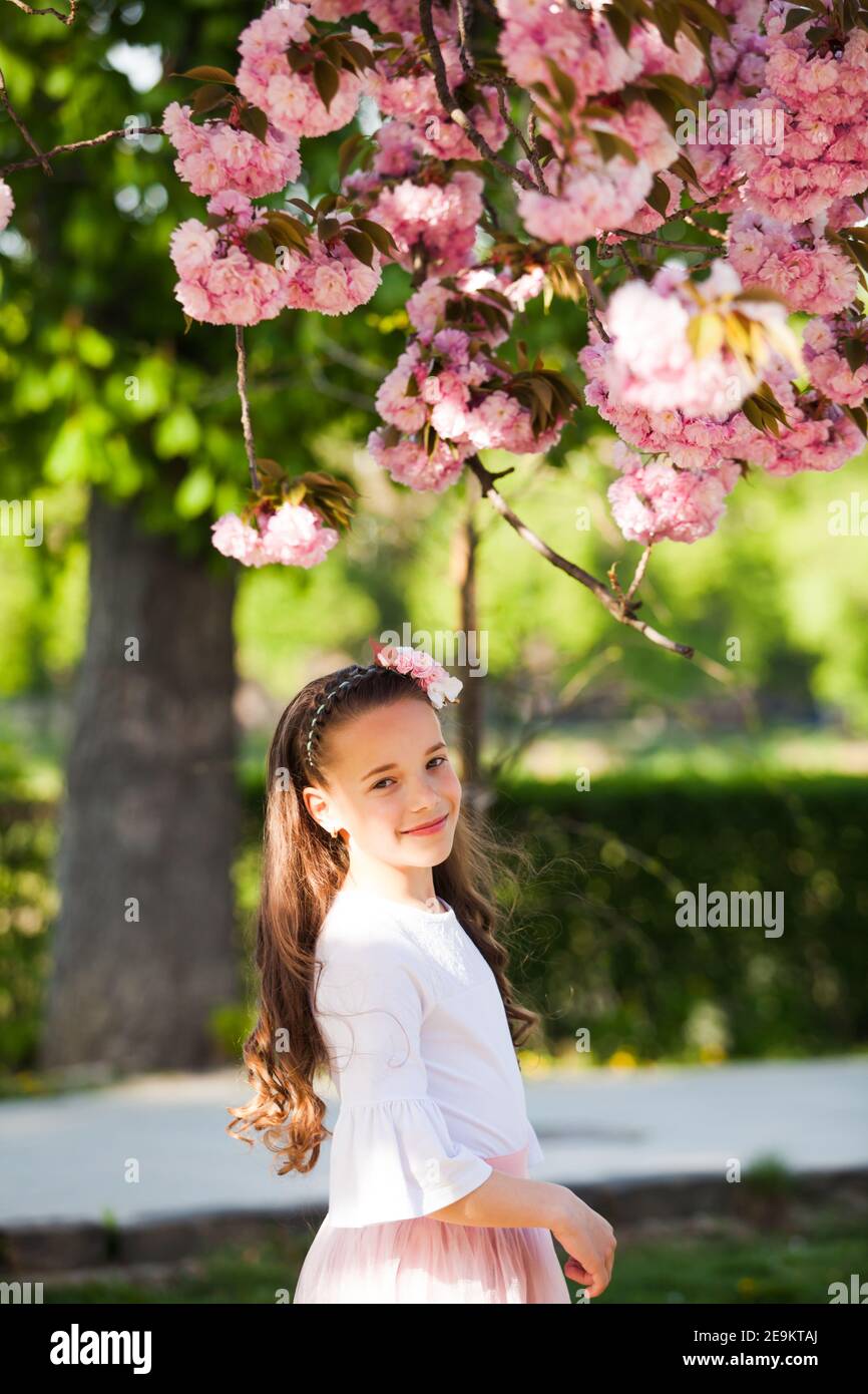the girl is standing under the pink tree that bloom Stock Photo - Alamy