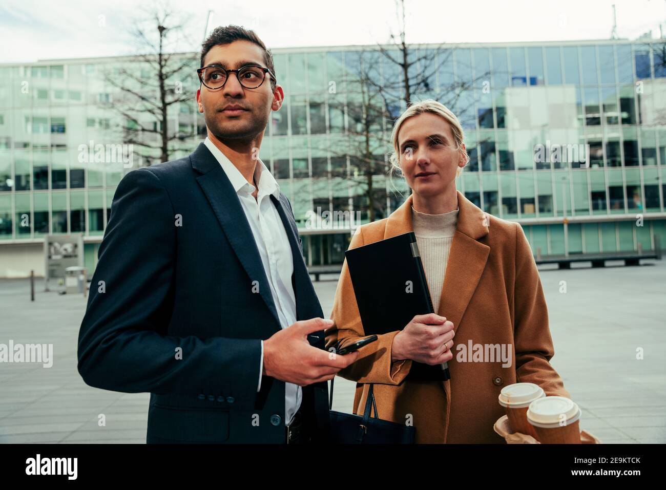 Focused colleagues chatting over coffee before work starts Stock Photo ...