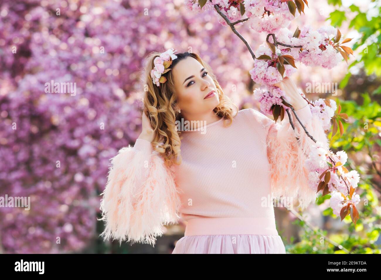 the girl is standing under the pink tree that bloom Stock Photo - Alamy
