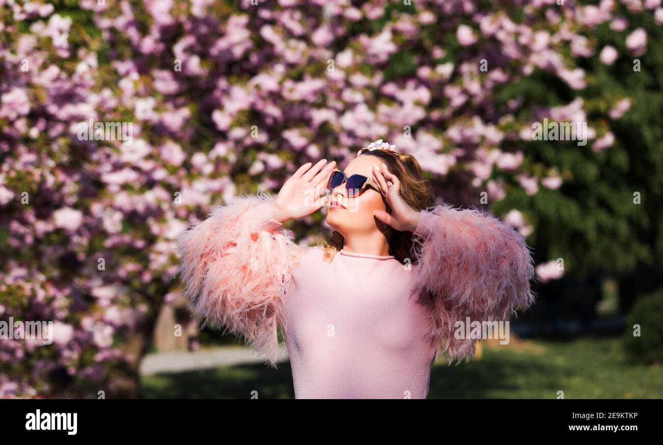 the girl is standing under the pink tree that bloom Stock Photo - Alamy