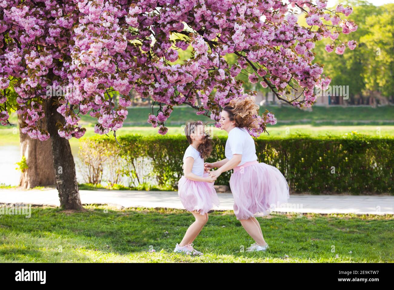 mom and daughter are standing next to a tender plant Stock Photo - Alamy