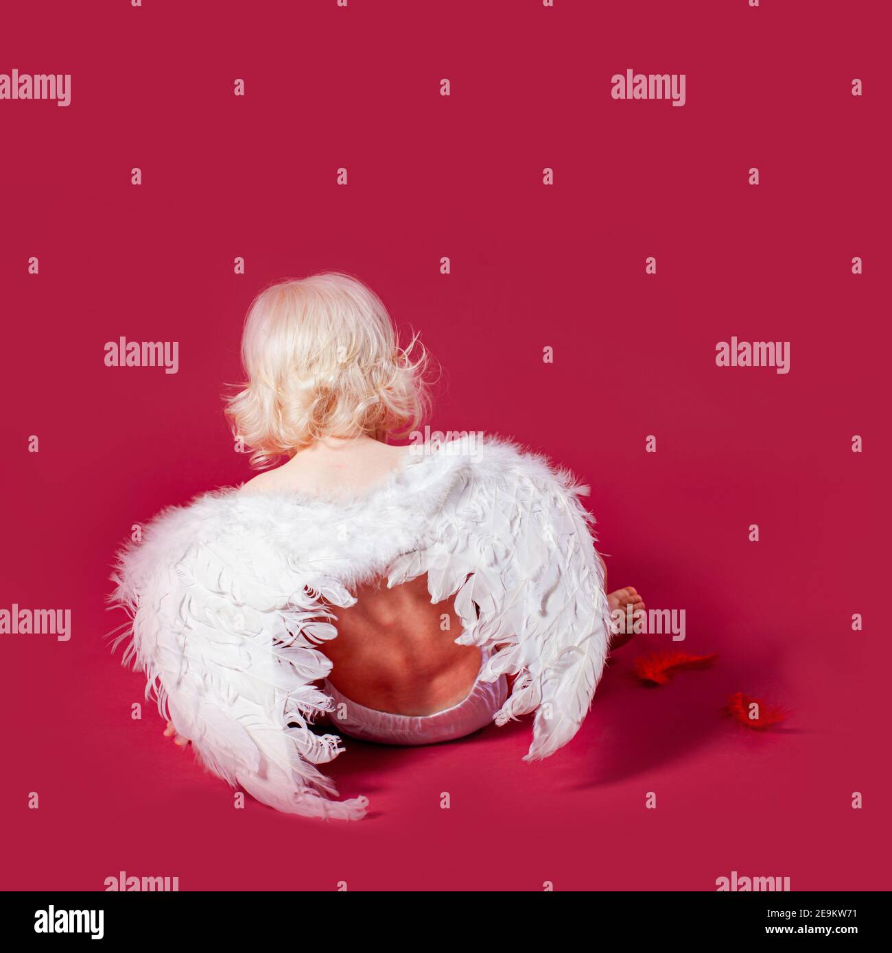 Back view of curly little angel. Cupid sitting Stock Photo - Alamy