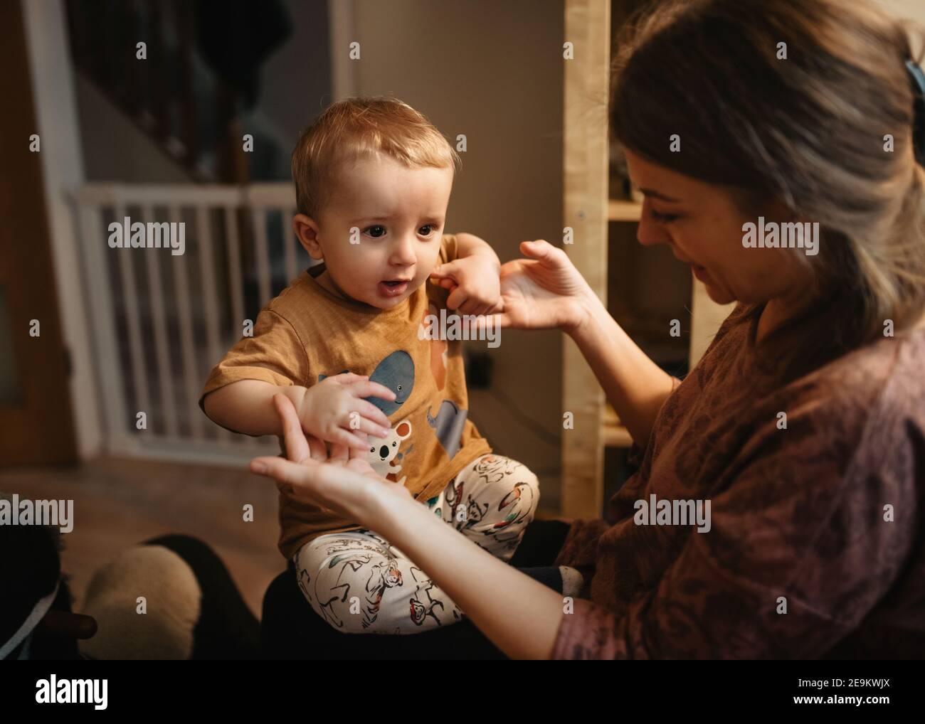 child sitting on mother legs Stock Photo - Alamy