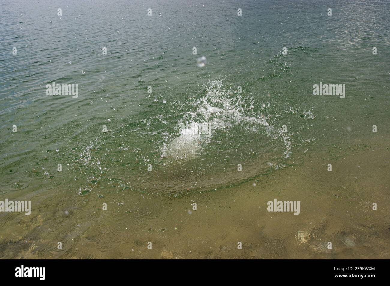 Splashes, ripples, circles created by stones thrown into the sea, drop ...