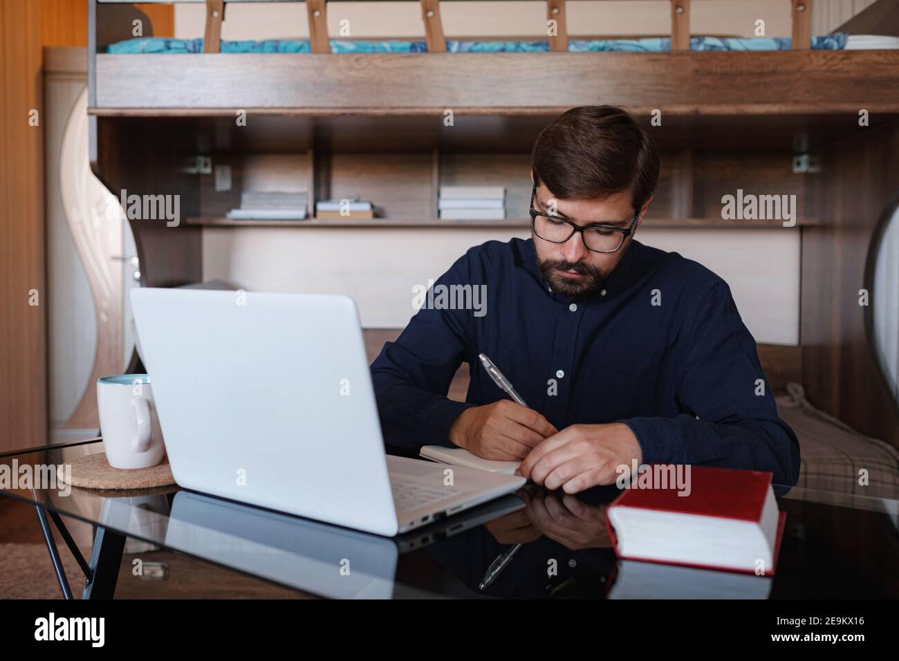 Focused serious male student using laptop looking at computer screen ...