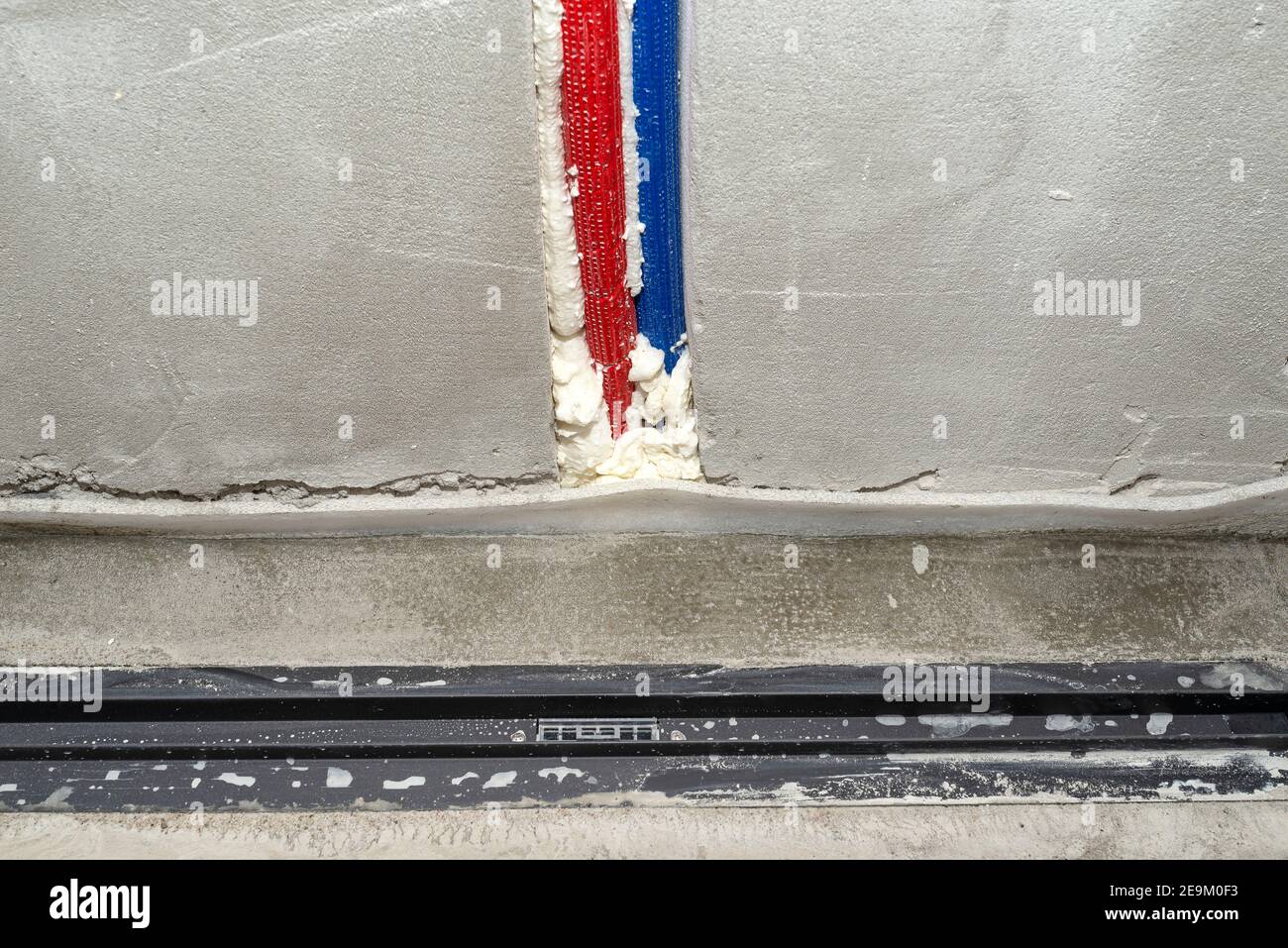 A modern black linear shower drain installed in the shower floor ...